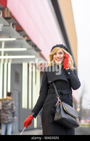 Stylish french woman talking by phone, nice joke, smiling. Young lady ...