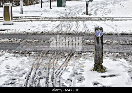 Signpost with cycle route and pedestrian crossing ahead against blue ...