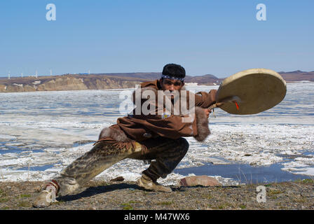 Chukchi man in traditional clothes is dancing a folk dance with ...