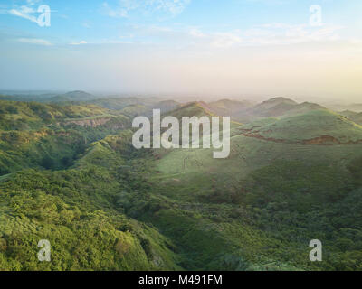 Aerial view of mountain hills covered with dense green lush woods on ...