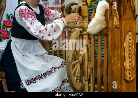 Young woman spinning thread on a spinning wheel. Black-and-white photo ...