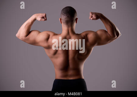 Male bodybuilder flexing his biceps, back view Stock Photo - Alamy