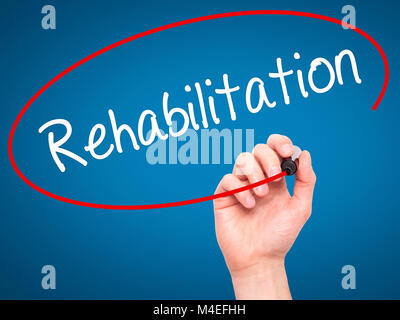 Man Hand writing Rehabilitation with black marker on visual screen ...