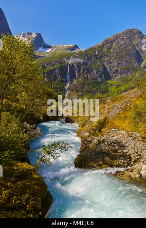 A scenic view of a fjord near Briksdal Glacier under blue cloudy sky in ...