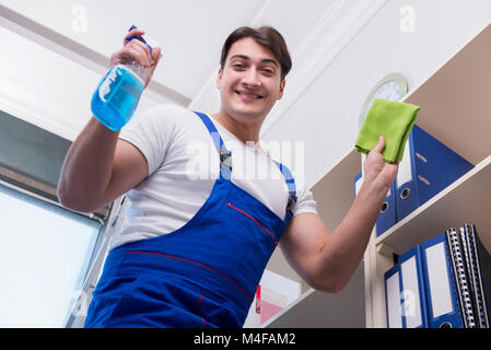 The male office cleaner cleaning shelves in office Stock Photo - Alamy
