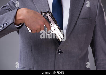 Businessman pulling the gun out of pocket Stock Photo - Alamy