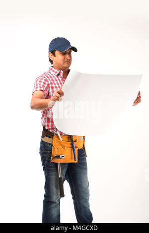 Indian plumber posing with Pipe wrench or plumbing spanner, standing ...