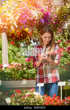 Young woman professional gardener using mattock during working at land ...