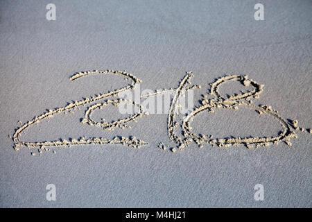 The 2018 written on the sand while the wave is cancelling the 8 ...