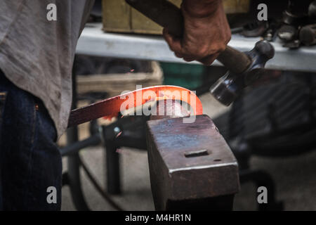 A blacksmith hammering hot iron Stock Photo - Alamy