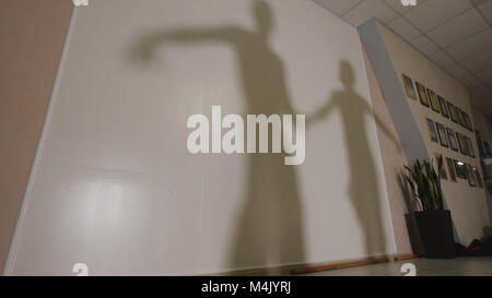 Shadow of man and woman dancing and rehearsing Latin American dance in ...