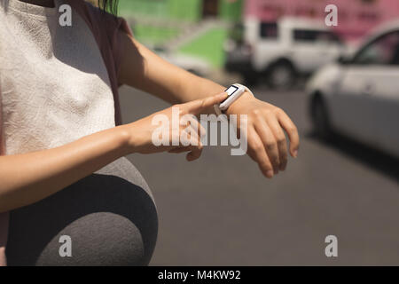 Pregnant woman using smartwatch Stock Photo - Alamy