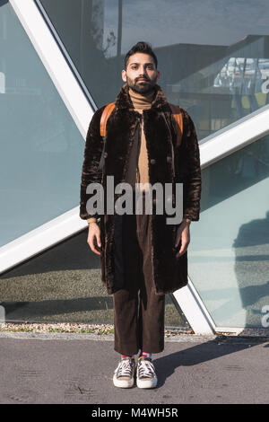 Handsome and fashionable indian man in black sitting at room, smoking ...
