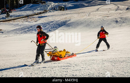 An injured skier on a rescue sledge after being helped by the ski ...