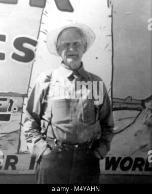 BERT LOPER, COLORADO RIVER RUNNER, STANDS IN FRONT OF BILLBOARD. HANDS ...