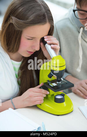 happy teen girl using microscope. back to school. study biology ...