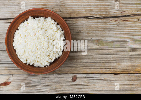 cottage cheese on clay dish with wooden spoon on kitchen tablecloth ...