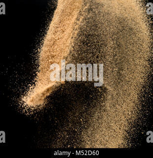 Yellow sand explosion isolated on black background. Abstract sand cloud ...