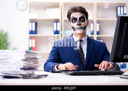 Businessman with scary face mask working in office Stock Photo - Alamy