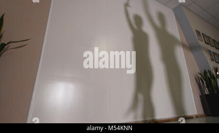 Shadow of man and woman dancing and rehearsing Latin American dance in ...