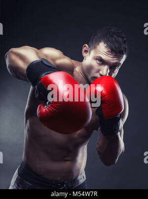 Boxing concept. Boxer with an aggressive look in white boxing gloves ...