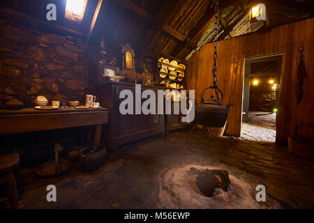 Original interior of the kitchen area with paet fire burning in The Blackhouse, 24 Arnol, Bragar ...