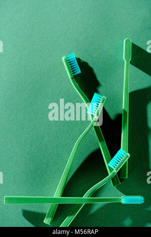 minimalistic background with green toothbrushes with shadows, on green ...