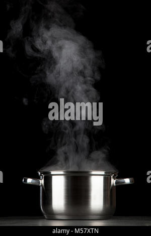 Steaming pot isolated on black background Stock Photo - Alamy