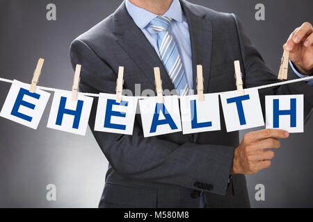 Businessman Pinning EHEALTH Cards On Clothesline Stock Photo - Alamy