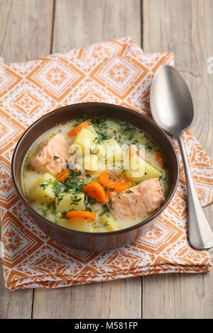 Finnish fish soup kalakeitto with salmon and cream on a rustic table ...