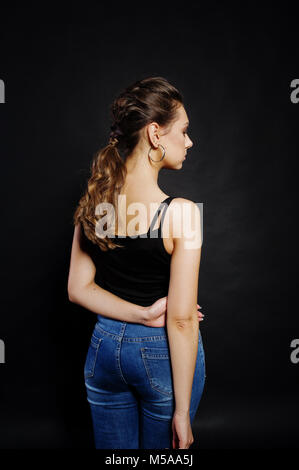 Studio portrait of back hairdress brunette girl on black background ...