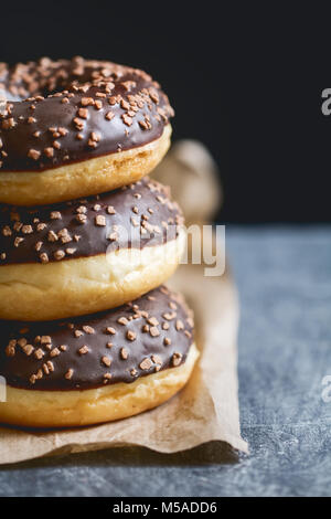 Stack of sweet chocolate donuts against black wall Stock Photo - Alamy