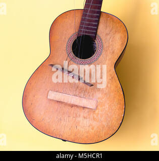 A broken wooden old classic guitar with damaged strings chords ...