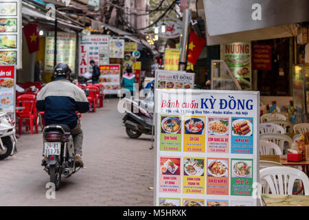 Restaurant with many menu signs outside and an indigenous woman running ...
