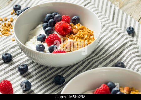 Bowl of natural yogurt with granola and fresh berries on wooden ...