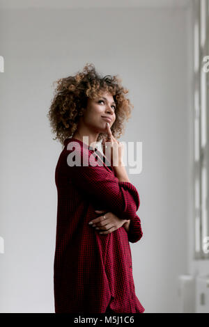 Image of attractive thinking woman with curly red hair holding exercise ...