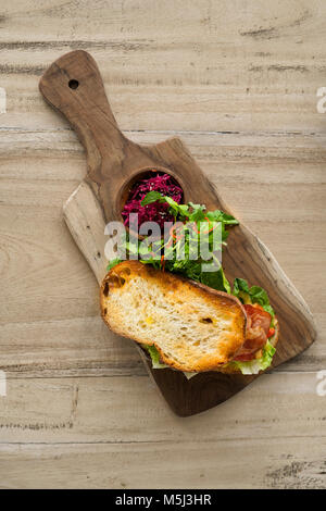Crusty bread with green salad and beetroot on wooden plate and green ...