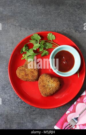 Heart shaped Cutlets in red plate with sauce and cilantro / Valentines ...