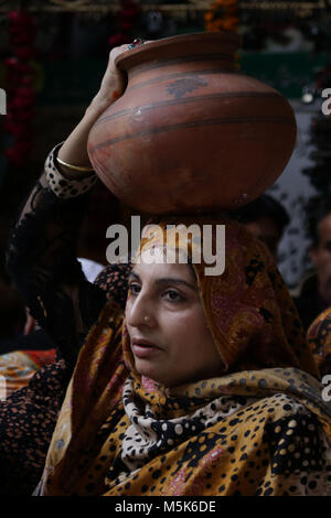 Pakistani women devotees carrying pitchers of rose water for ablution ...