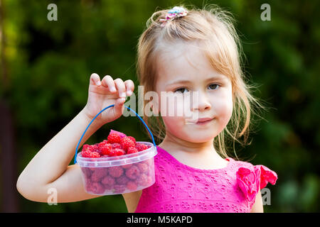 Portrait of a little girl child holdind small basket of ripe ...
