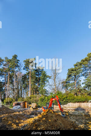 An excavator works on digging soil trenches in forest area under ...