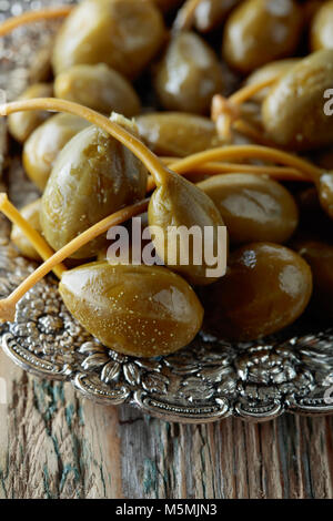 Pickled caper berries in metal dish . Edible fruits of Capparis ...