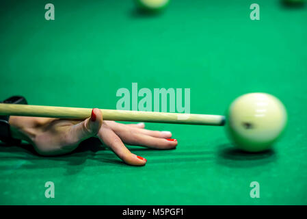 Woman's hand with cue playing pool Stock Photo - Alamy