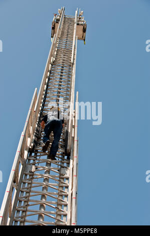 A firefighter climbing a ladder Stock Photo - Alamy