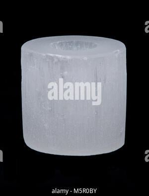 White selenite cylinder tea light holder on black background Stock ...