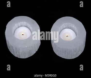 White selenite cylinder tea light holder on black background Stock ...