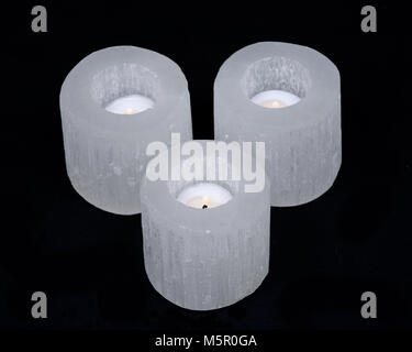 White selenite cylinder tea light holder on black background Stock ...