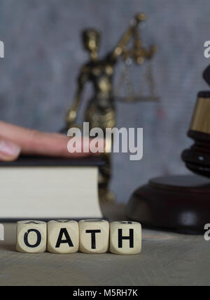 Word OATH composed of wooden letters. Statue of Themis,judge's gavel ...