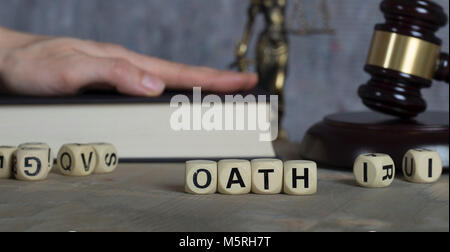 Word OATH composed of wooden letters. Statue of Themis,judge's gavel ...