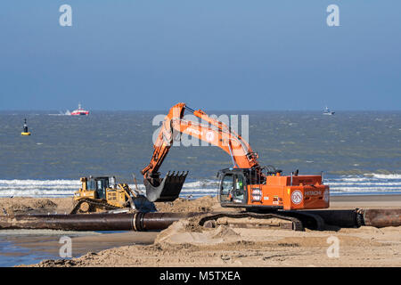 Hydraulic excavator connecting pipes of pipeline during sand ...